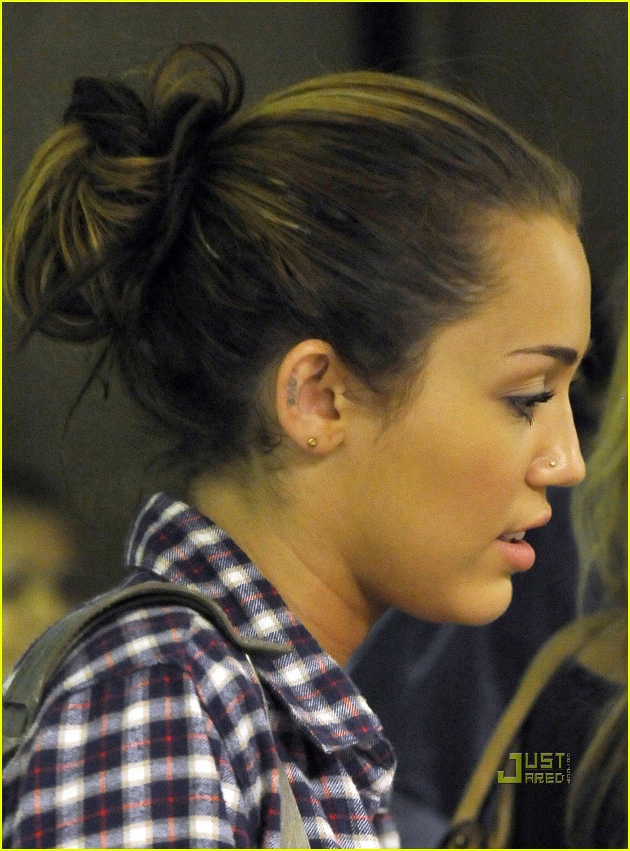 Miley Cyrus Sports Ear Tattoo, Partners with Paranormal Activity ...